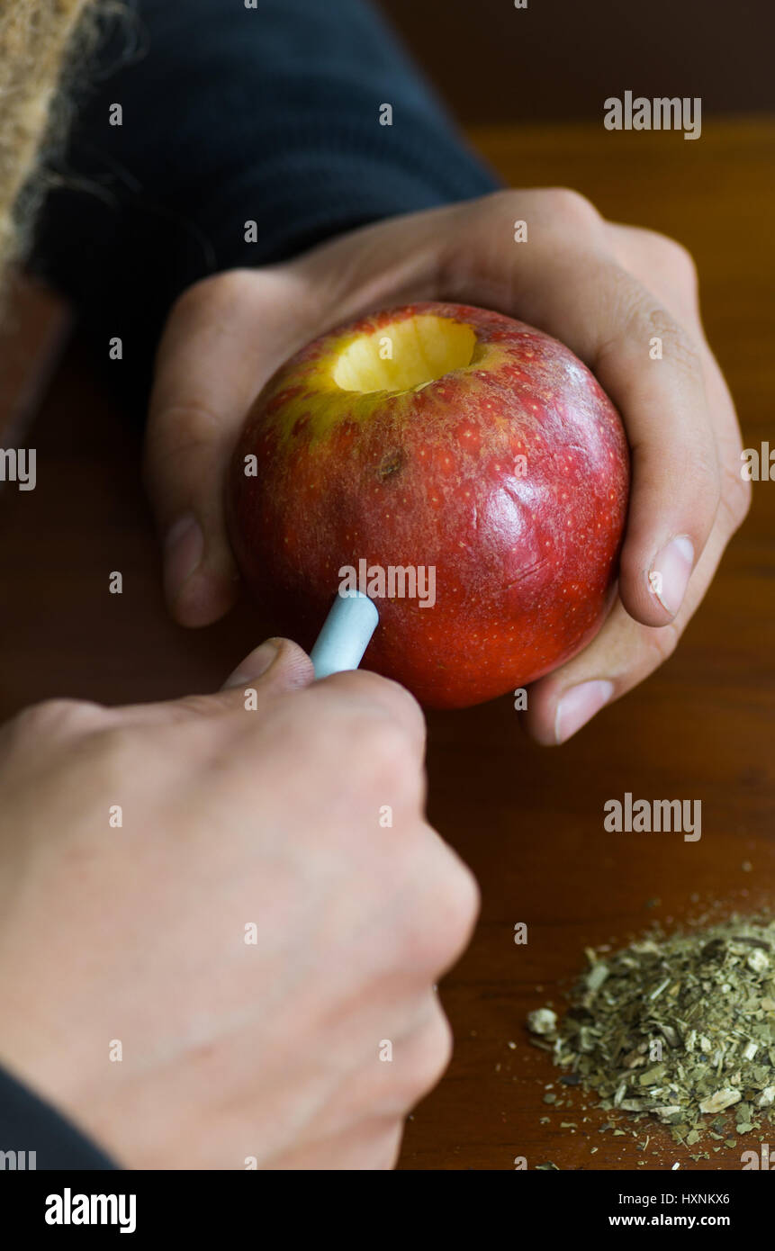 Man creating an apple bong using knife and a plastic tube, drug ...