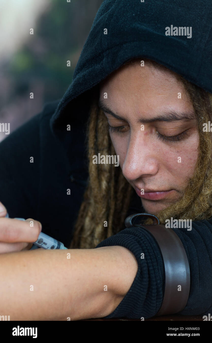 Man with drug addiction sitting down injecting narcotics into arm using ...