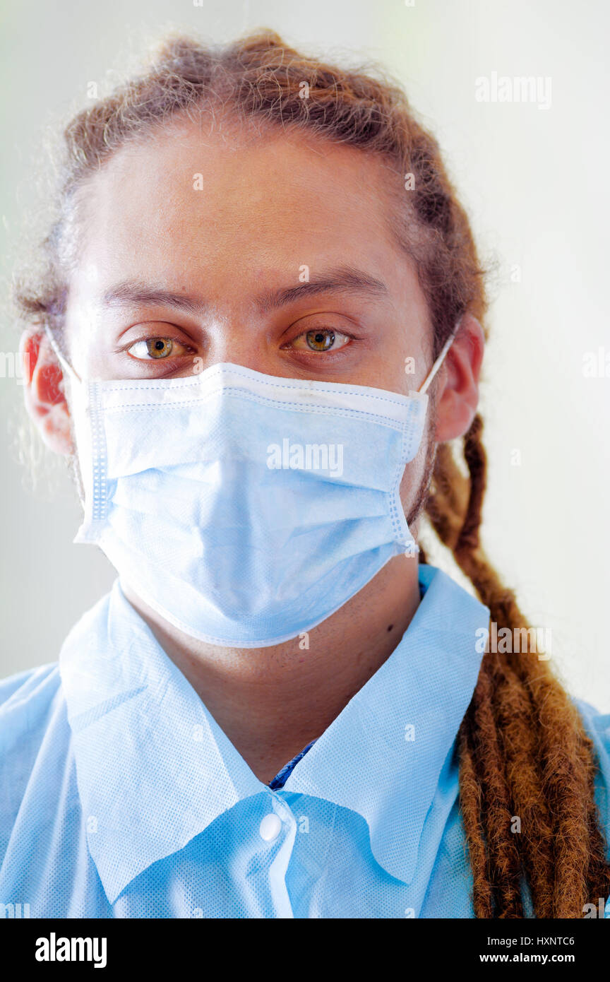 Young doctor with long dread locks posing for camera, wearing facial ...
