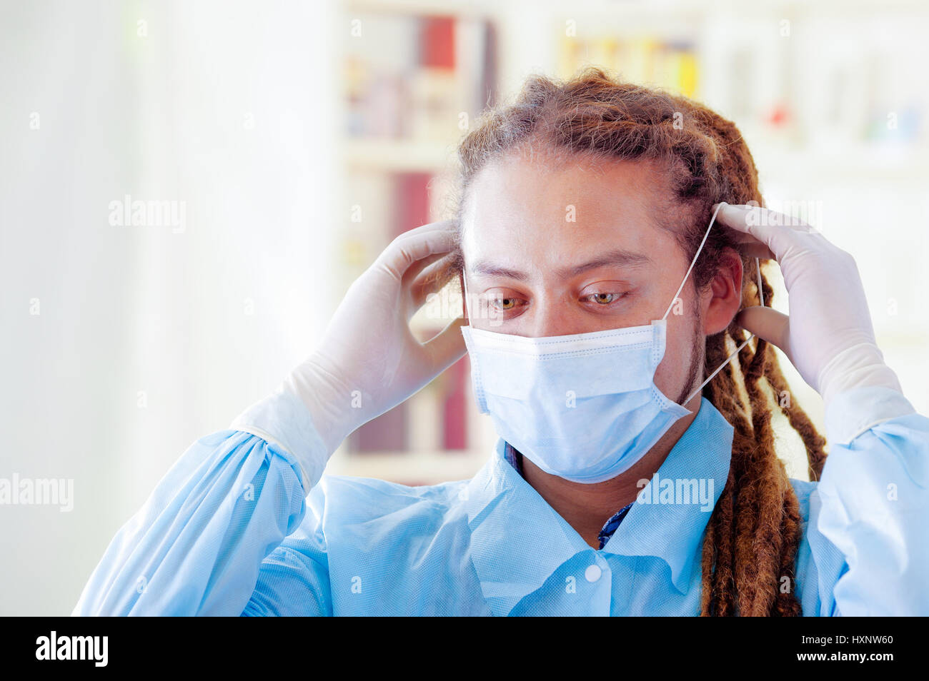 Young doctor with long dread locks posing for camera, adjusting facial ...