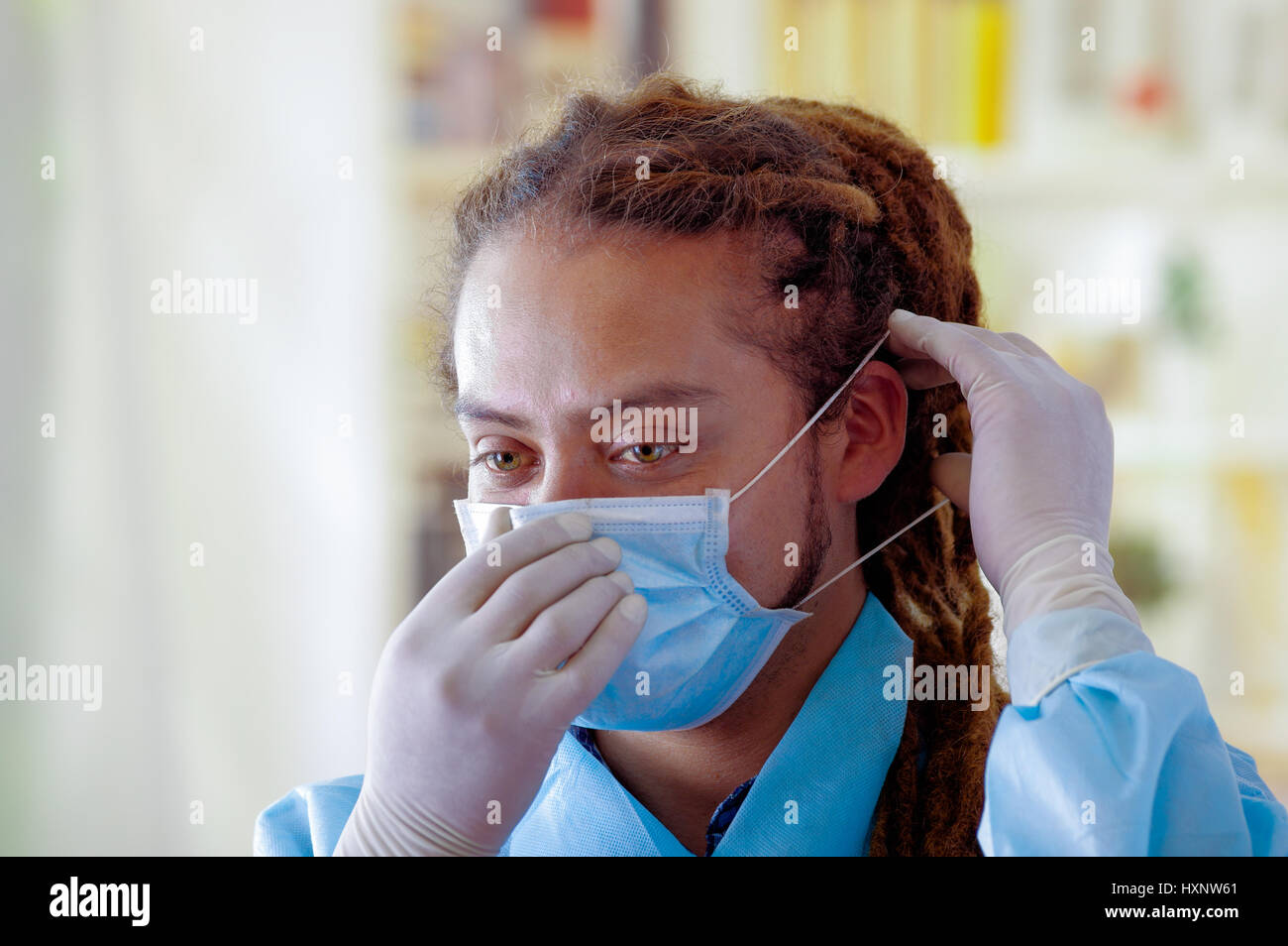 Young doctor with long dread locks posing for camera, adjusting facial ...