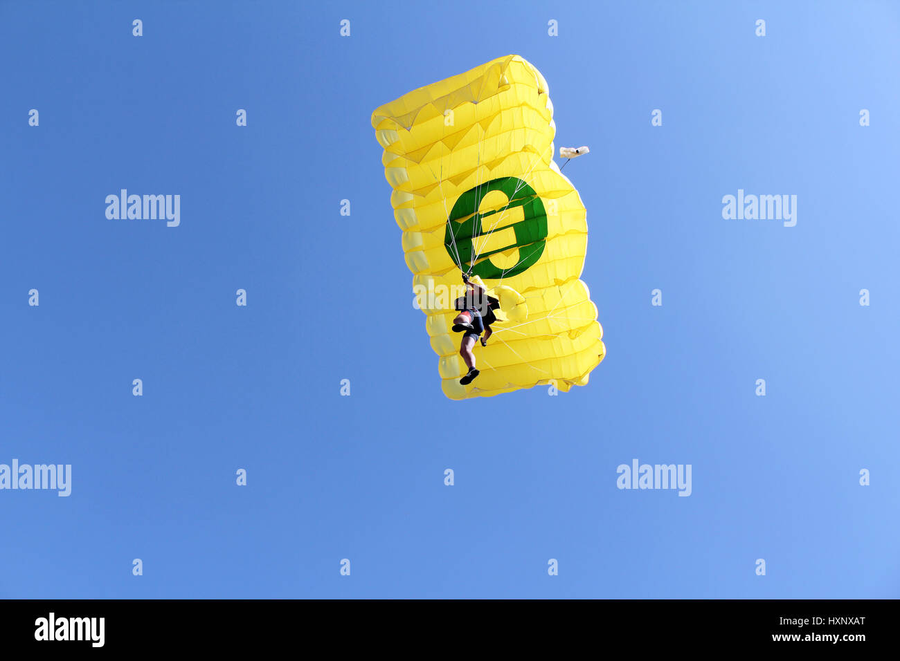 parachutist with yellow parachute on blue sky Stock Photo - Alamy