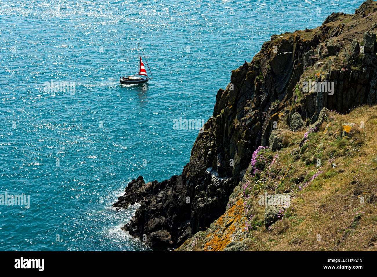 Cliffs with a small sailing boat below, at the Mull of Galloway ...