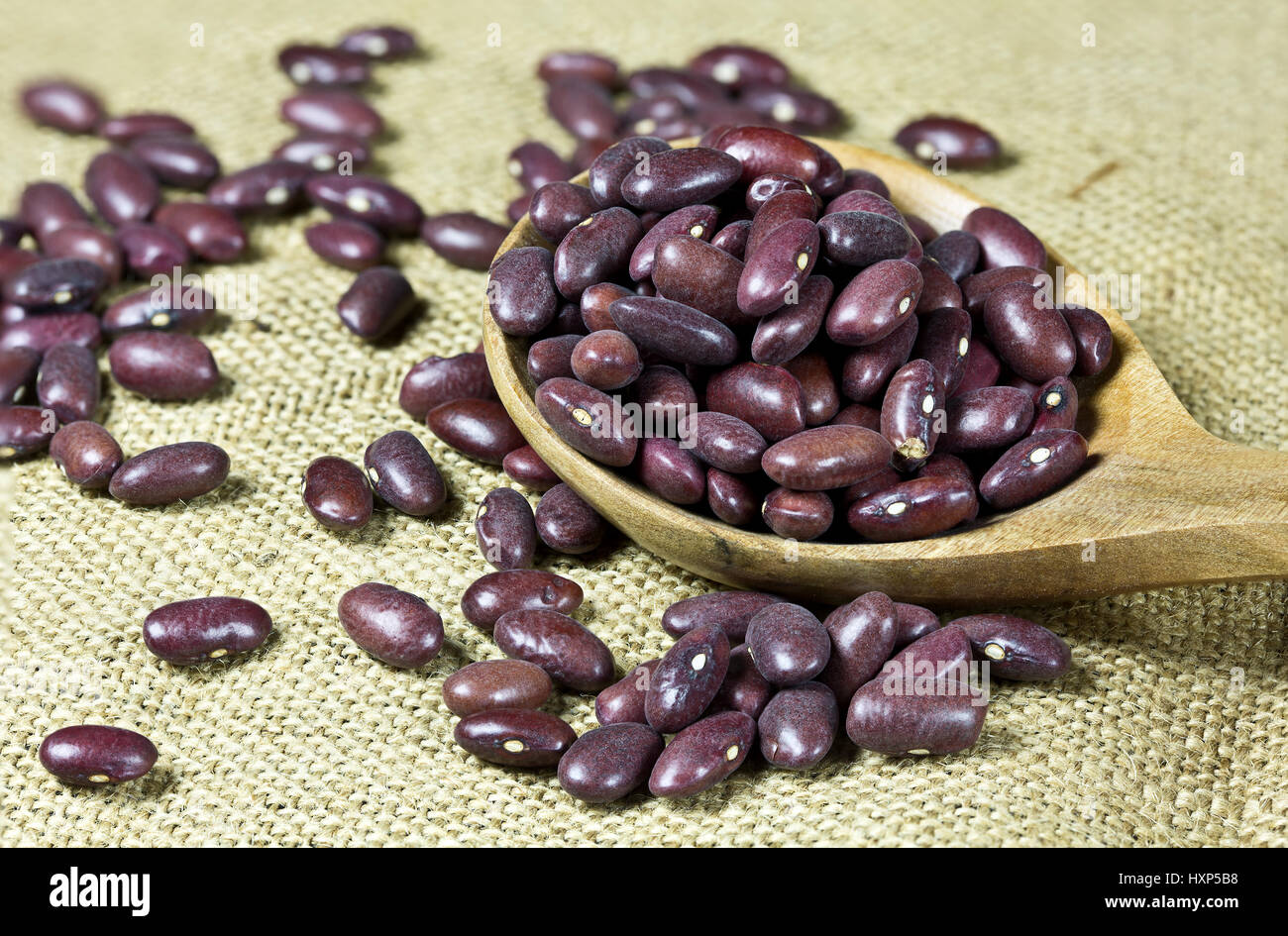 Red beans and wooden spoon on rustic background Stock Photo - Alamy