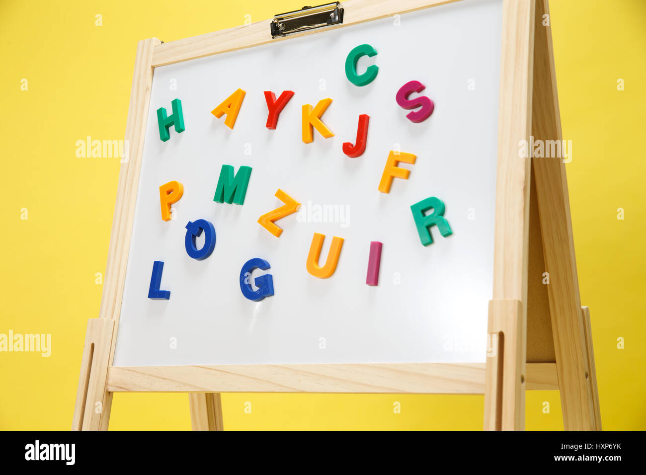 Colourful letter magnets being positioned on whiteboard Stock Photo - Alamy