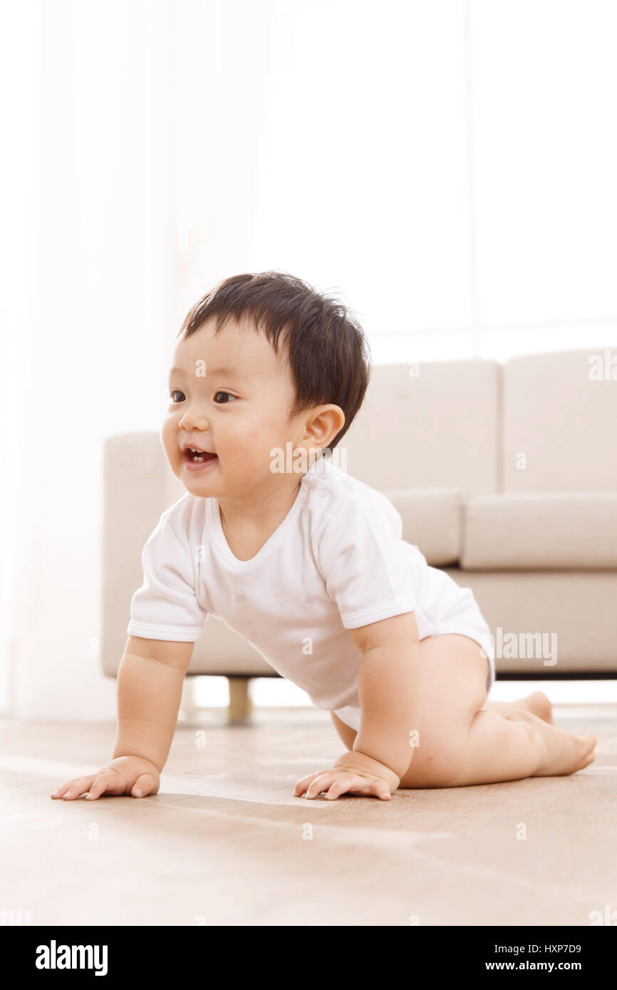 Baby crawling on floor Stock Photo - Alamy