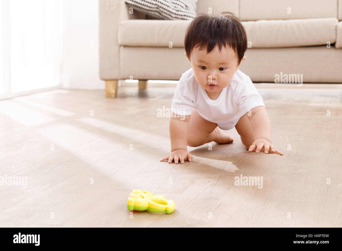 Baby boy crawling on floor Stock Photo - Alamy