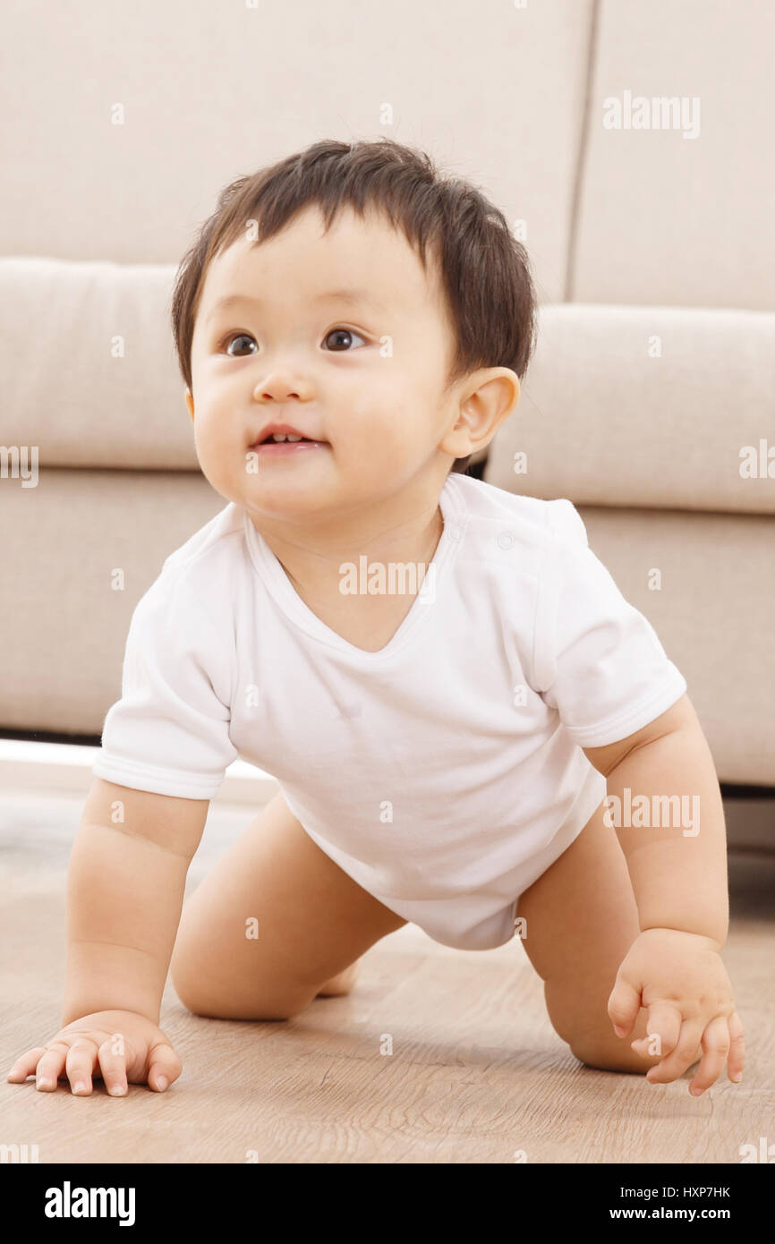 Baby boy crawling on floor Stock Photo - Alamy
