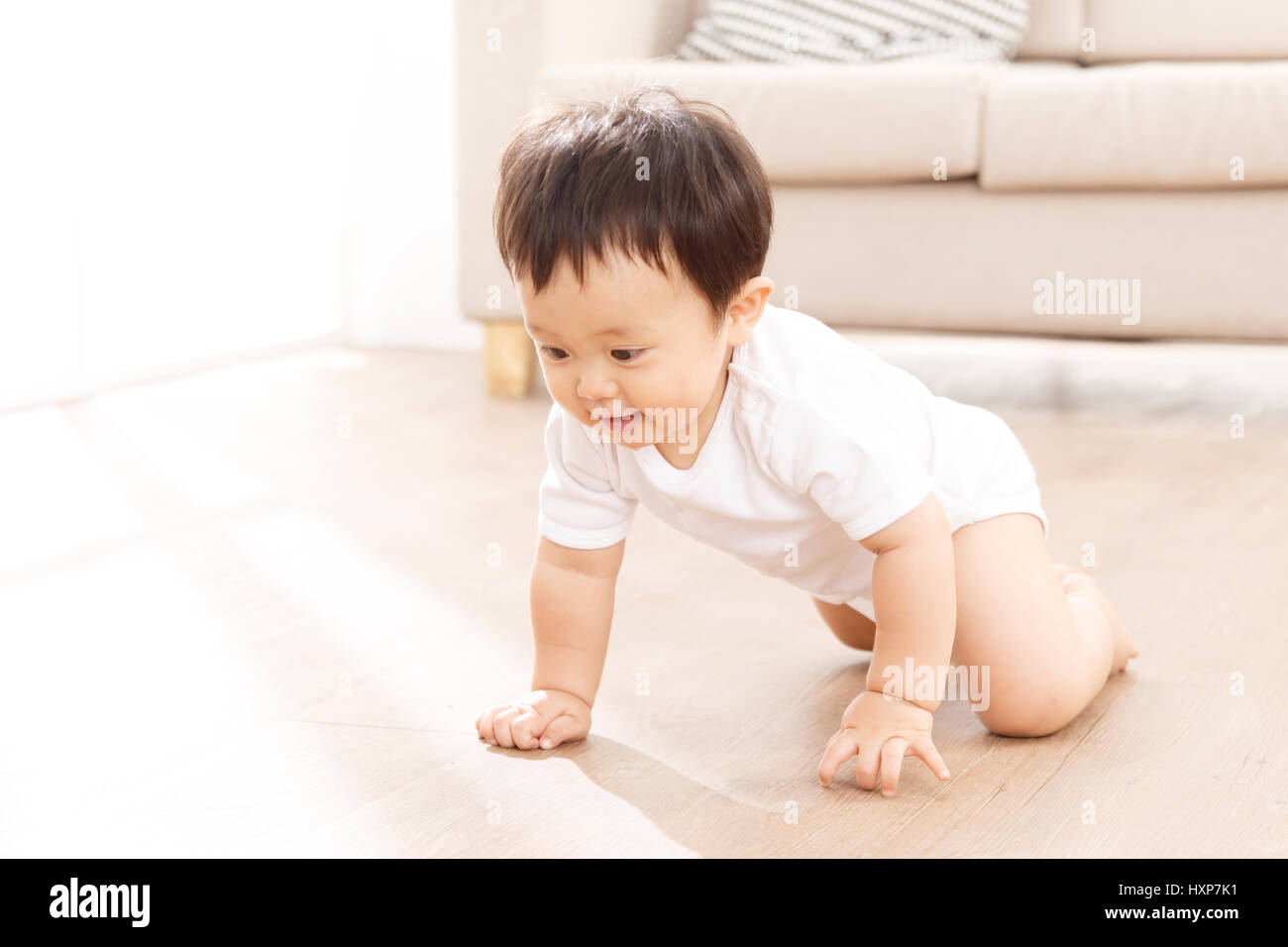 Baby boy crawling on floor Stock Photo - Alamy