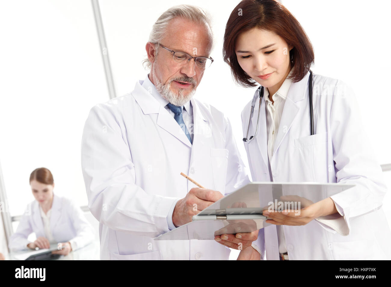 Doctors writing medical record Stock Photo - Alamy