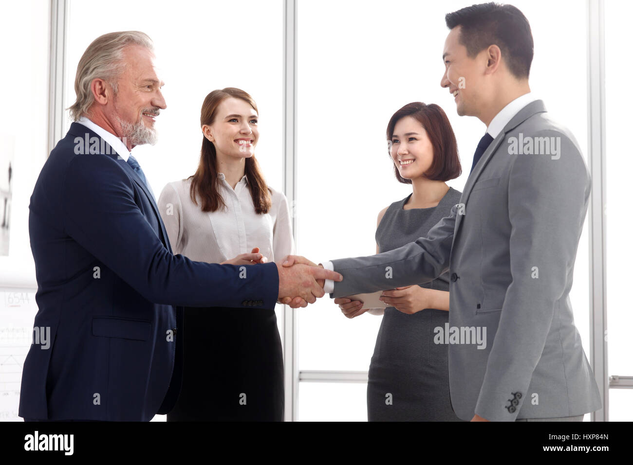 Authority standing smiling shaking hands looking up hi-res stock ...