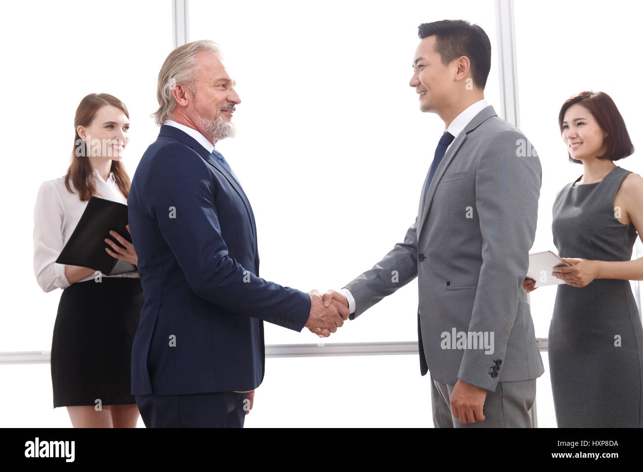 Businessmen shaking hands in meeting Stock Photo - Alamy