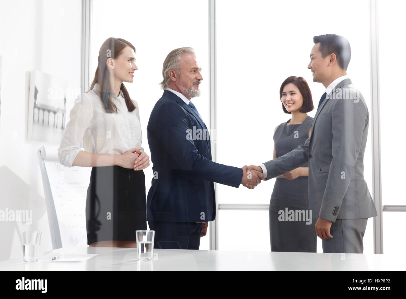Authority smiling face to face shaking hands looking standing hi-res stock photography and ...