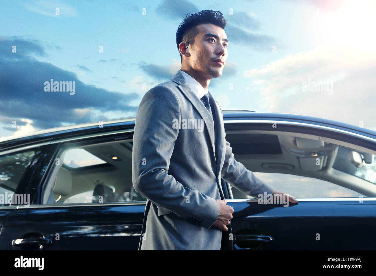 The young man stood by the car Stock Photo - Alamy
