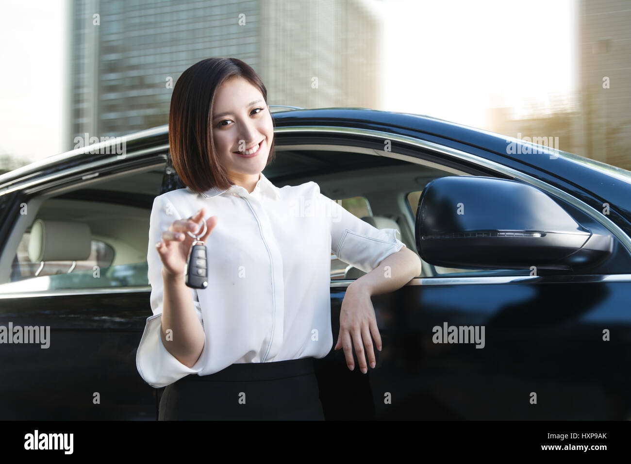 Young woman standing by car Stock Photo - Alamy