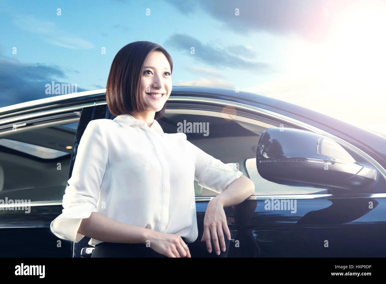 Young woman standing by car Stock Photo - Alamy