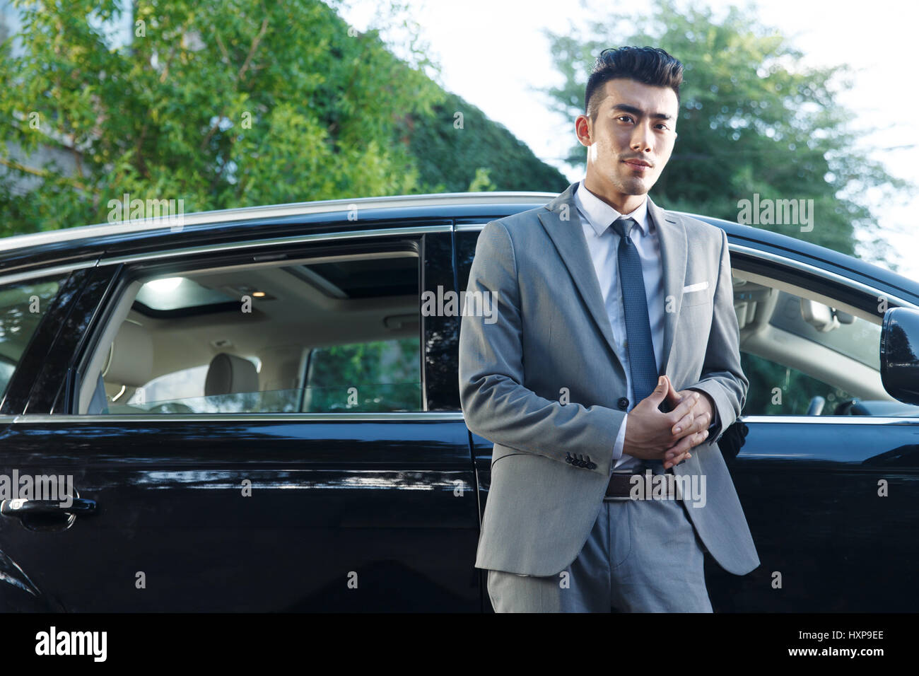 Young man standing by car Stock Photo - Alamy