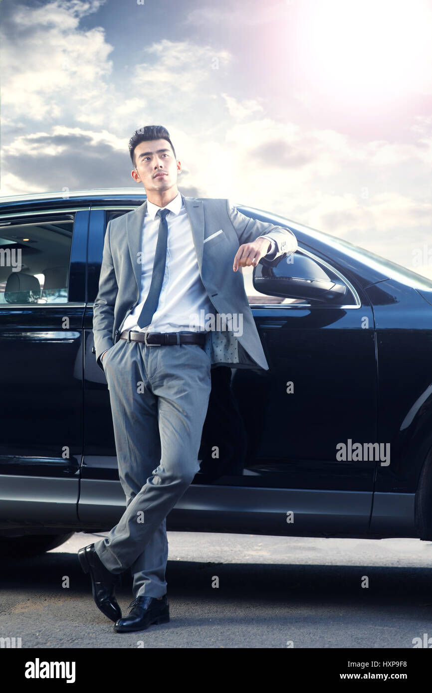 Young man standing by car Stock Photo - Alamy