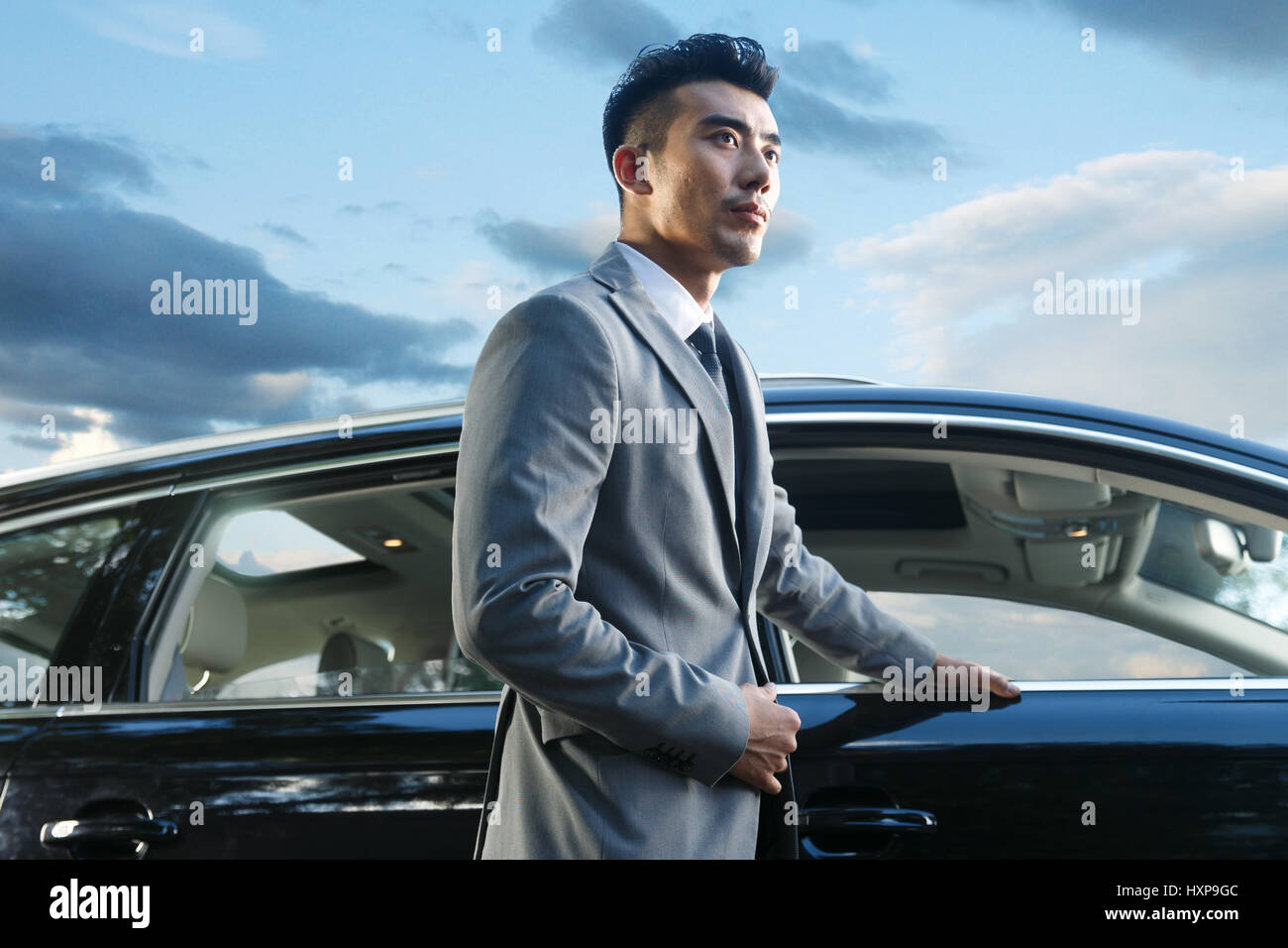 Young man standing by car Stock Photo - Alamy