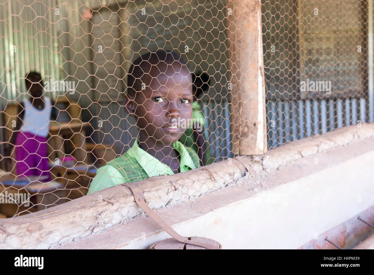 A school girl looks out from her classroom at a Bridge International ...