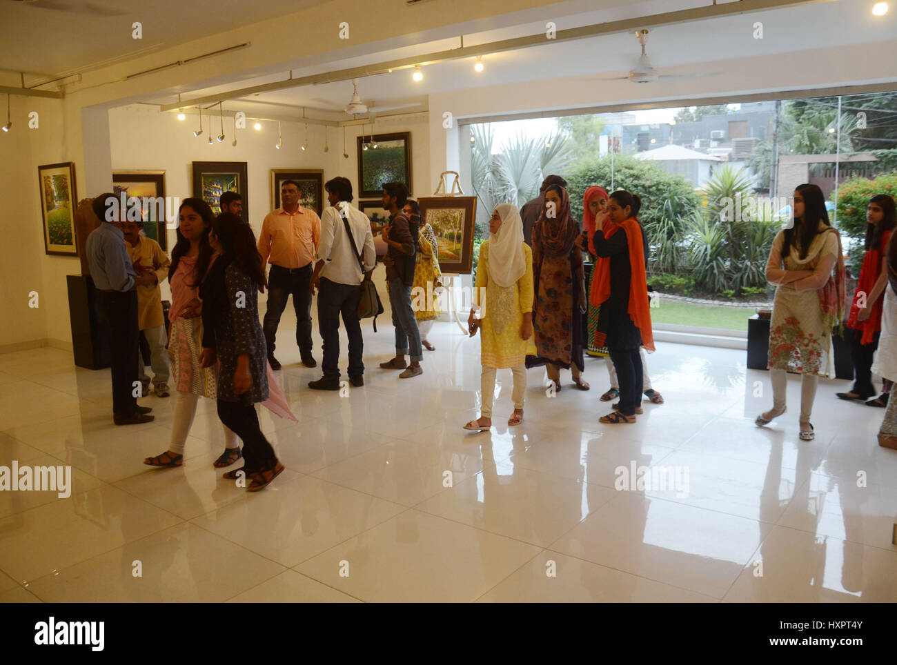 Pakistani visitors are viewing the paintings of Amjad Naeem during the ...