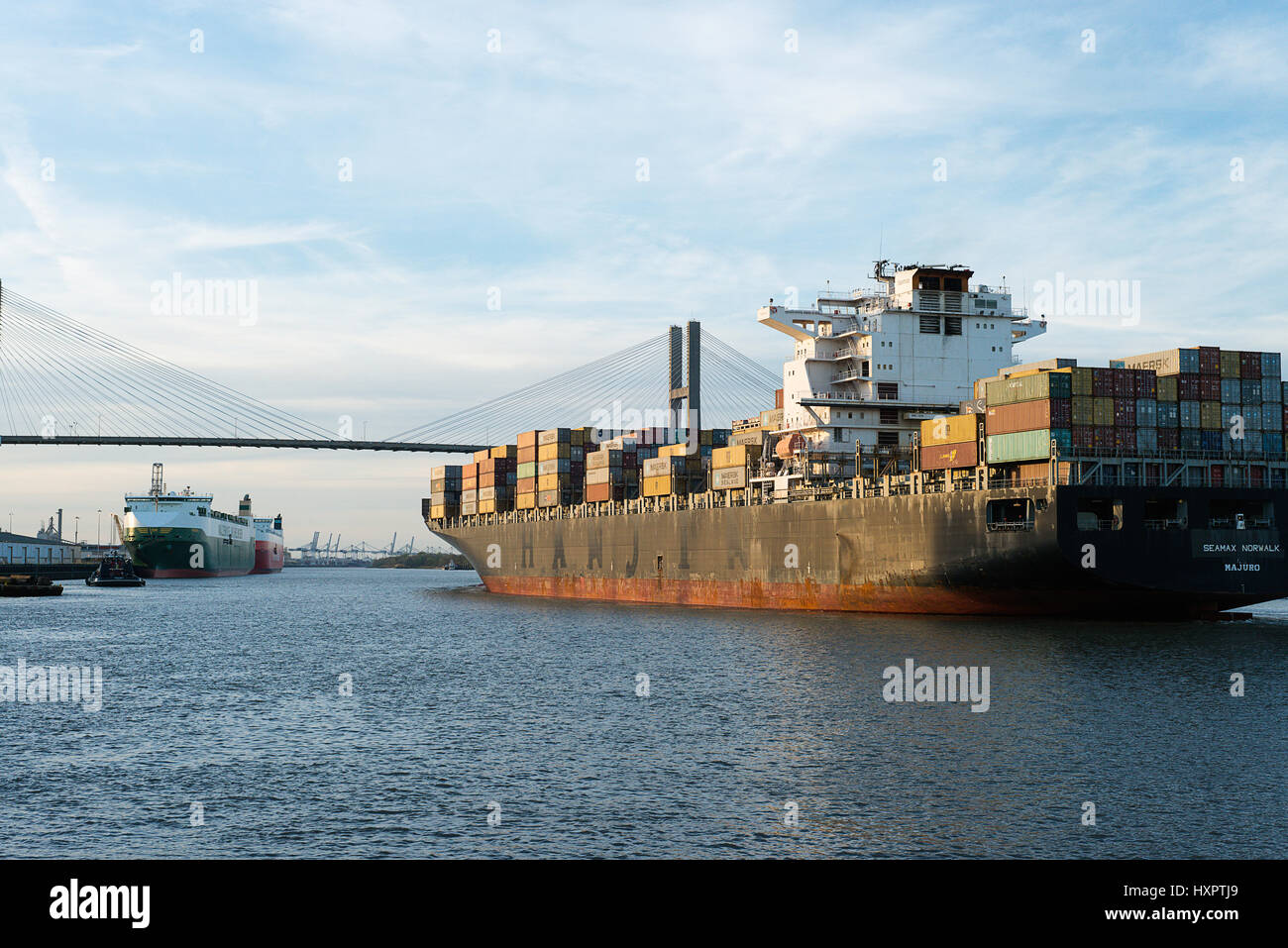 A container ship in Savannah Georgia with the Talmadge bridge in the ...