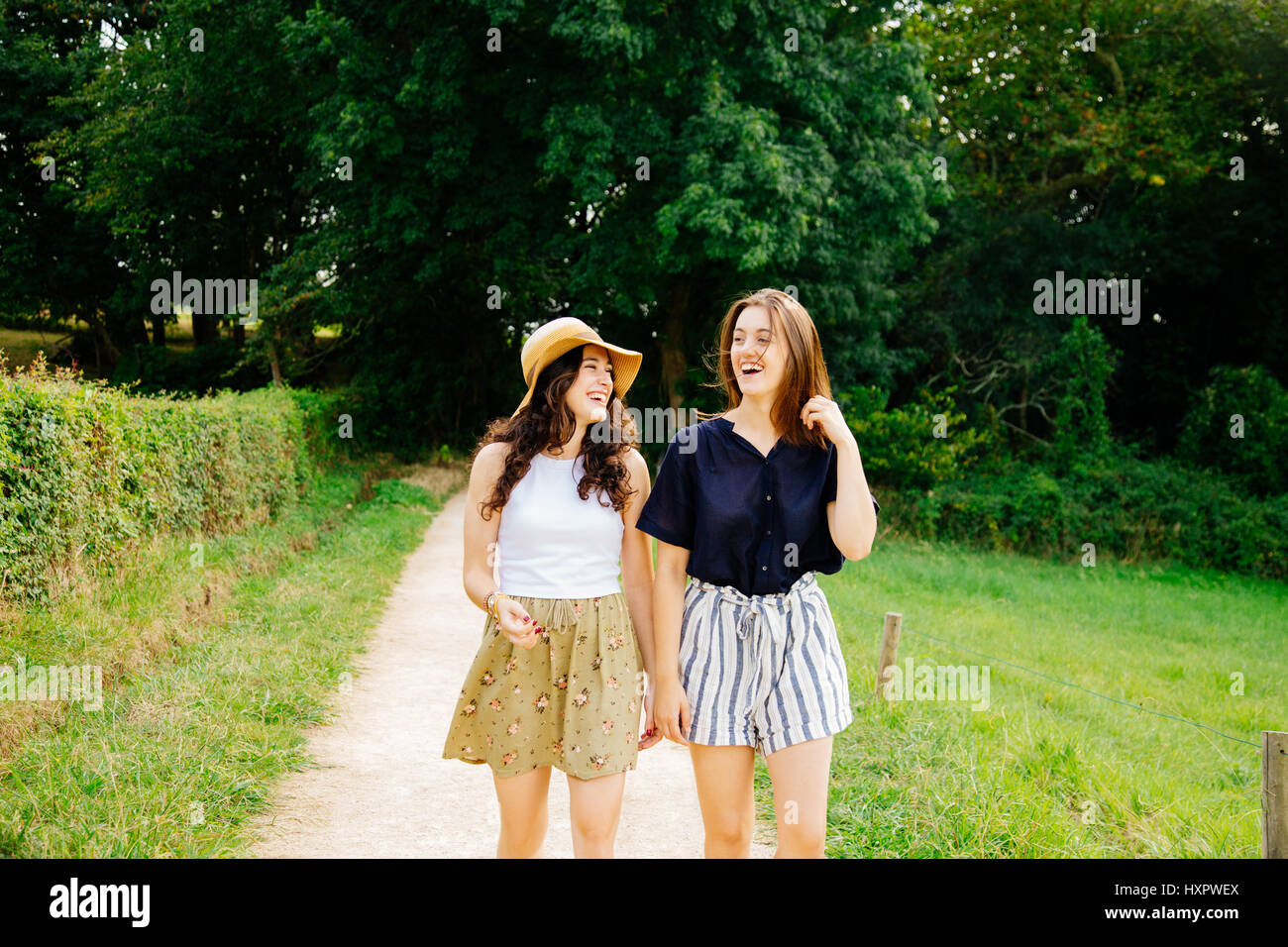Two female friends laughing while walking in the countryside Stock ...