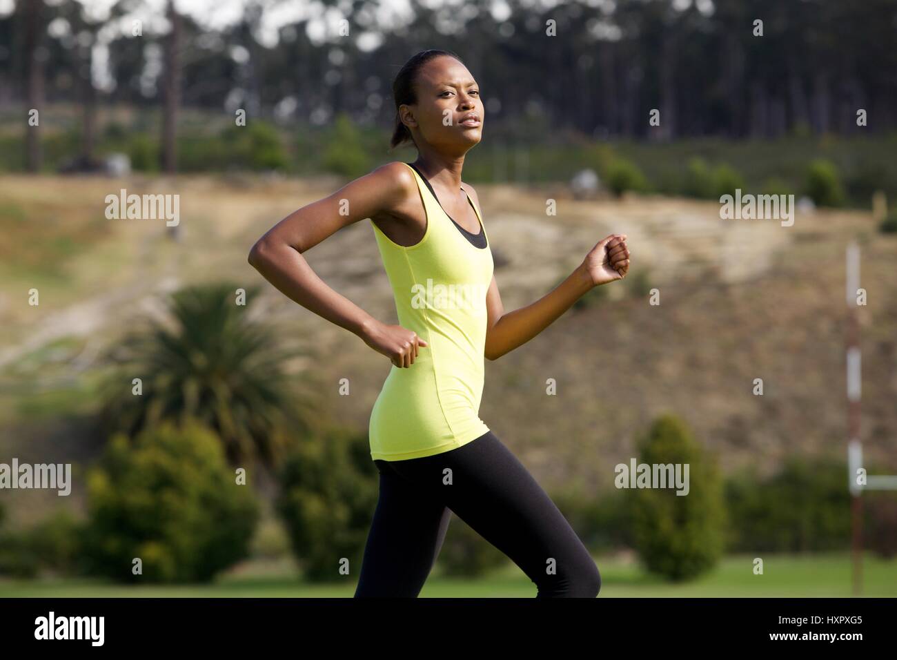 Side portrait of fit african woman running outdoors Stock Photo - Alamy