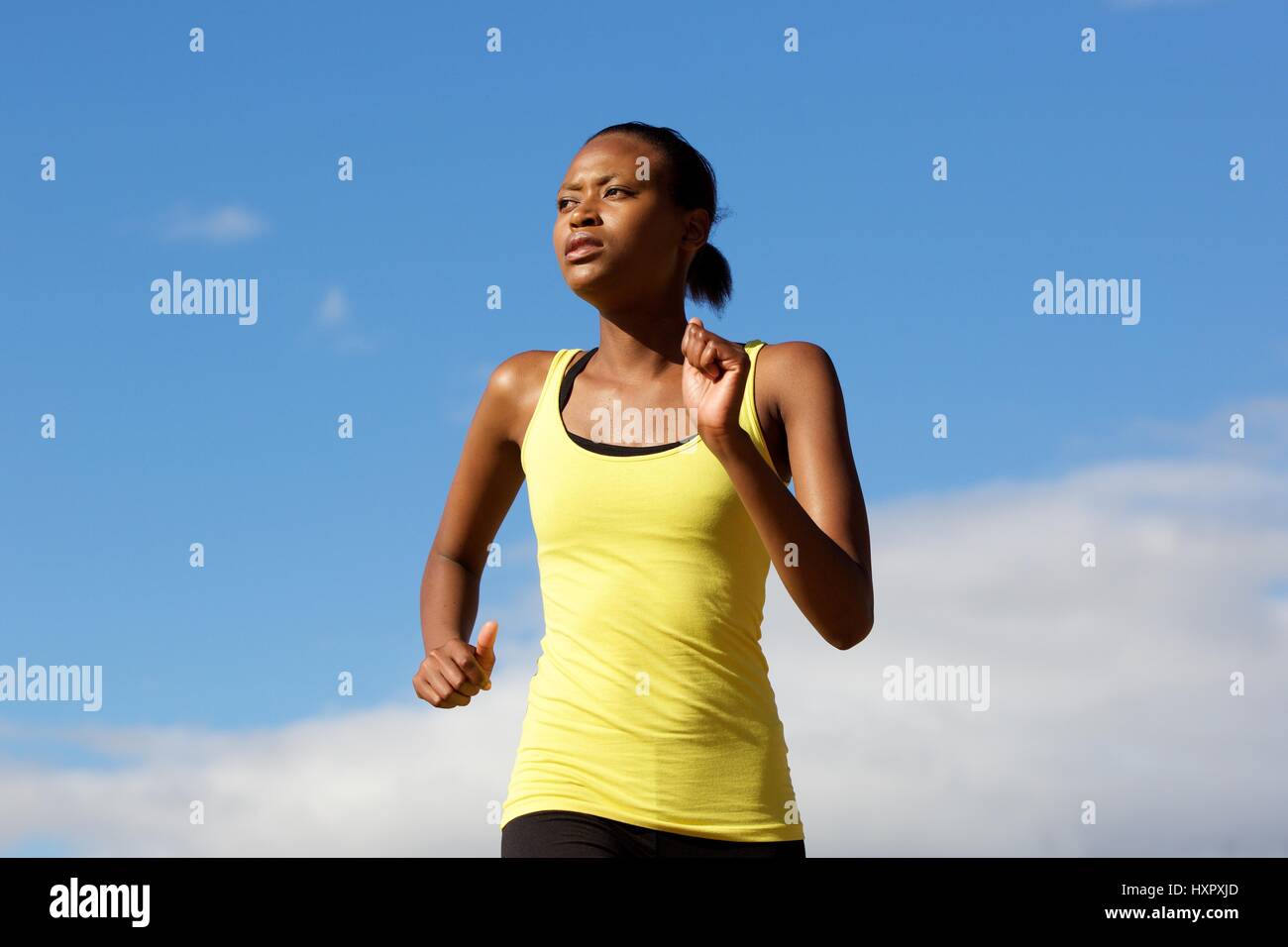 Portrait of young african woman running outdoors Stock Photo - Alamy