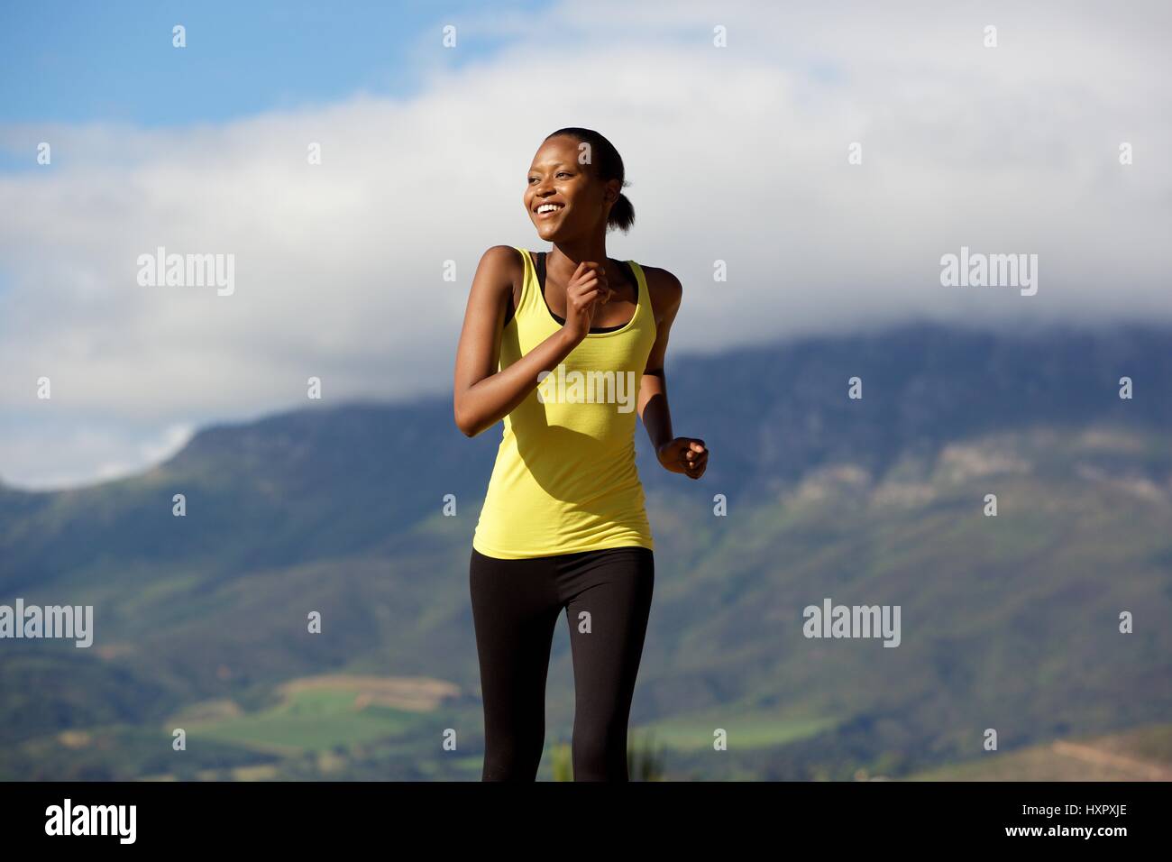 Portrait of happy young african woman running outdoors in nature Stock ...