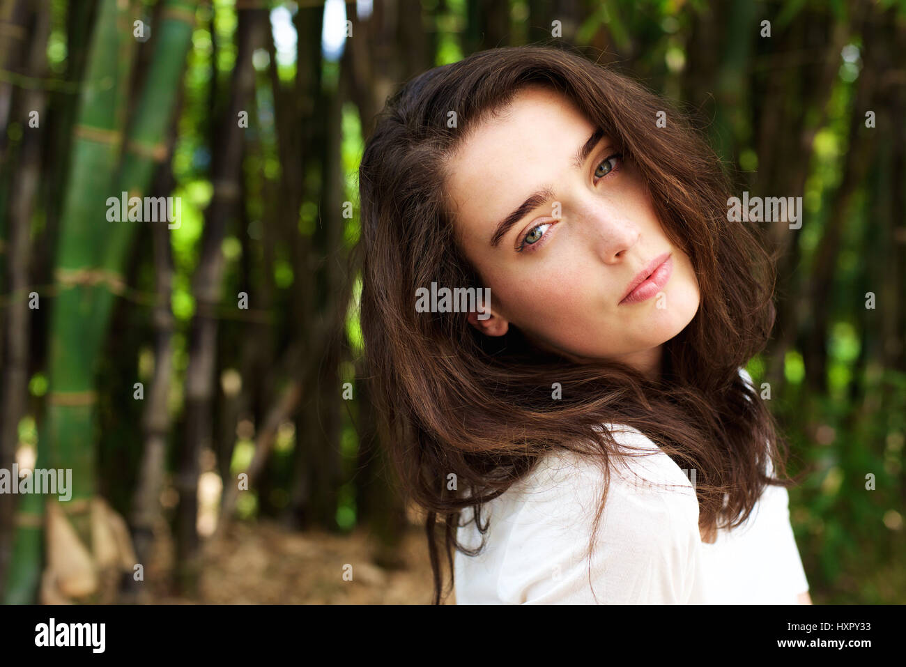 Close up portrait of attractive young woman tilting head in front of ...