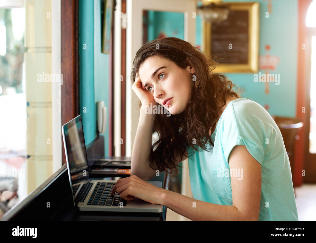 Portrait of university student with laptop looking out of window Stock ...