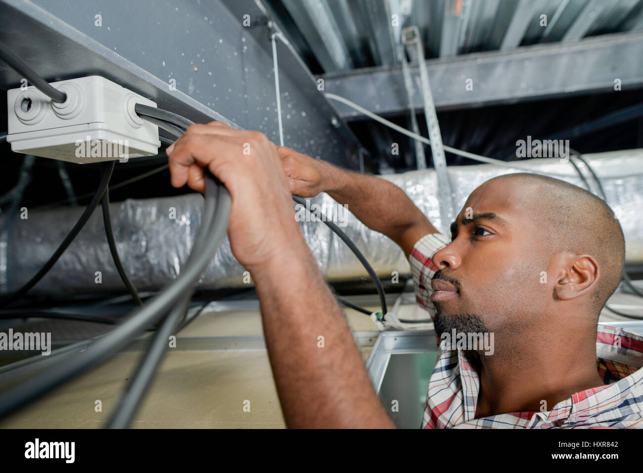 Electrician working on ceiling wiring Stock Photo - Alamy