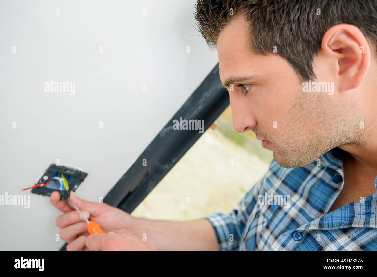 Man working on electric installation Stock Photo - Alamy