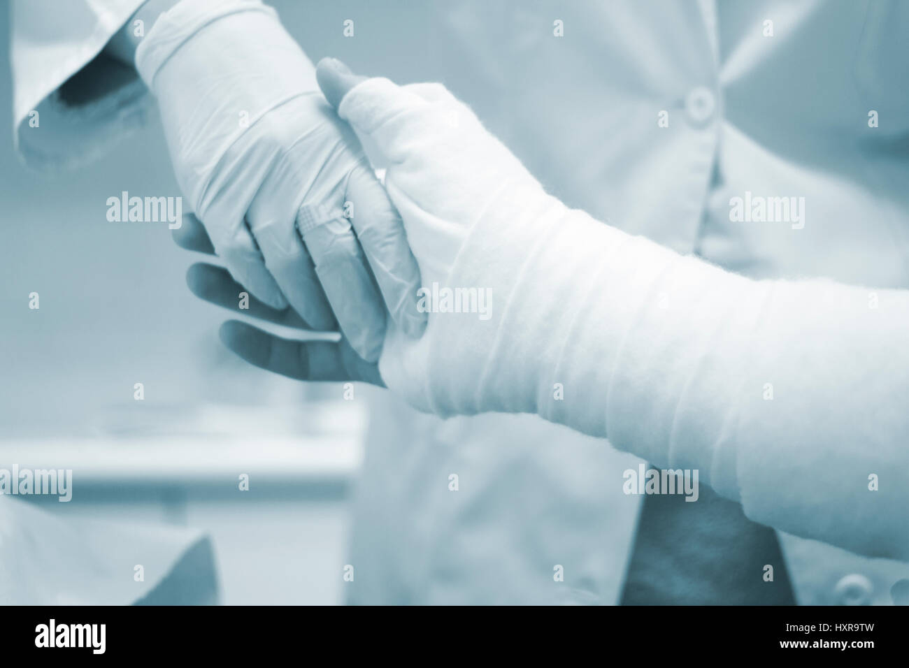 Doctor applying a plaster cast and bandages to patient forearm and ...