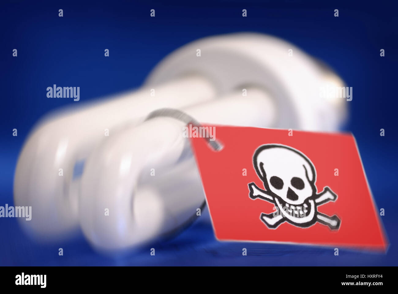Energy savings lamp with death's-head label, symbolic photo poison ...