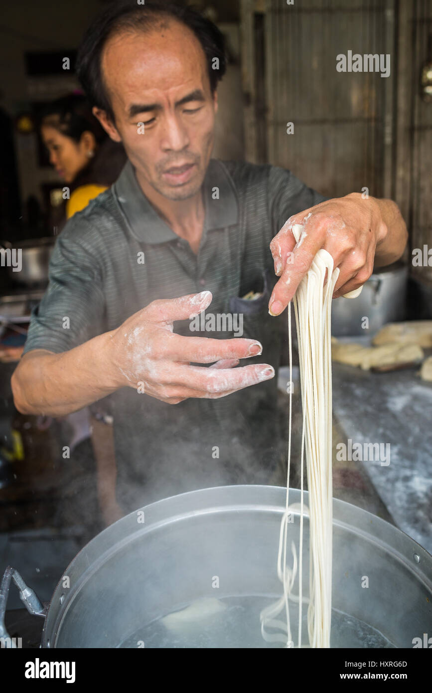 Street scene with Chef cooks hand made noodles in the Battambang ...