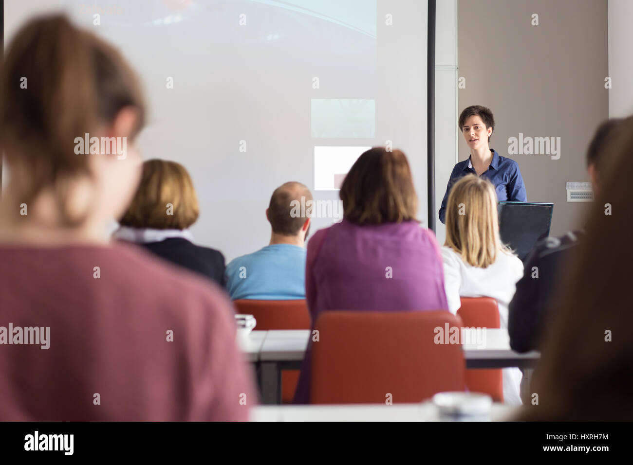 Female speaker giving presentation in lecture hall at university ...