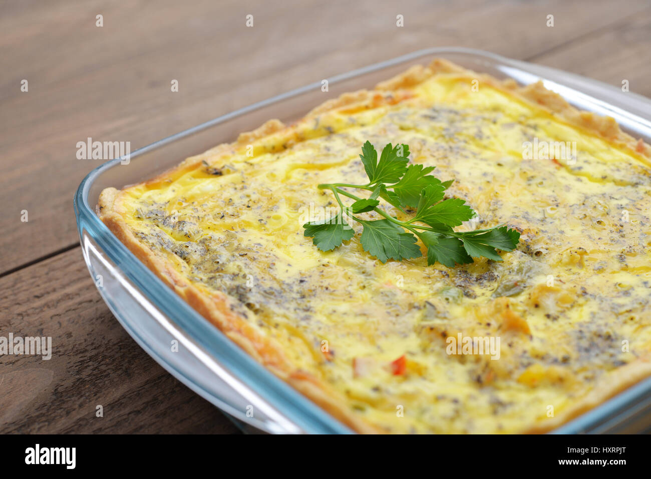 Quiche lorraine in square baking form on wooden background Stock Photo ...