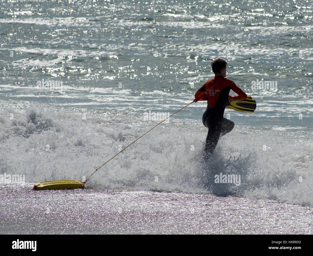 Lifeguard running into the sea, Pays de la Loire, France Stock Photo ...