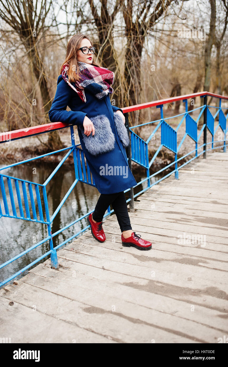 Young hipster girl wear on coat,scarf and glasses stay on small bridge ...