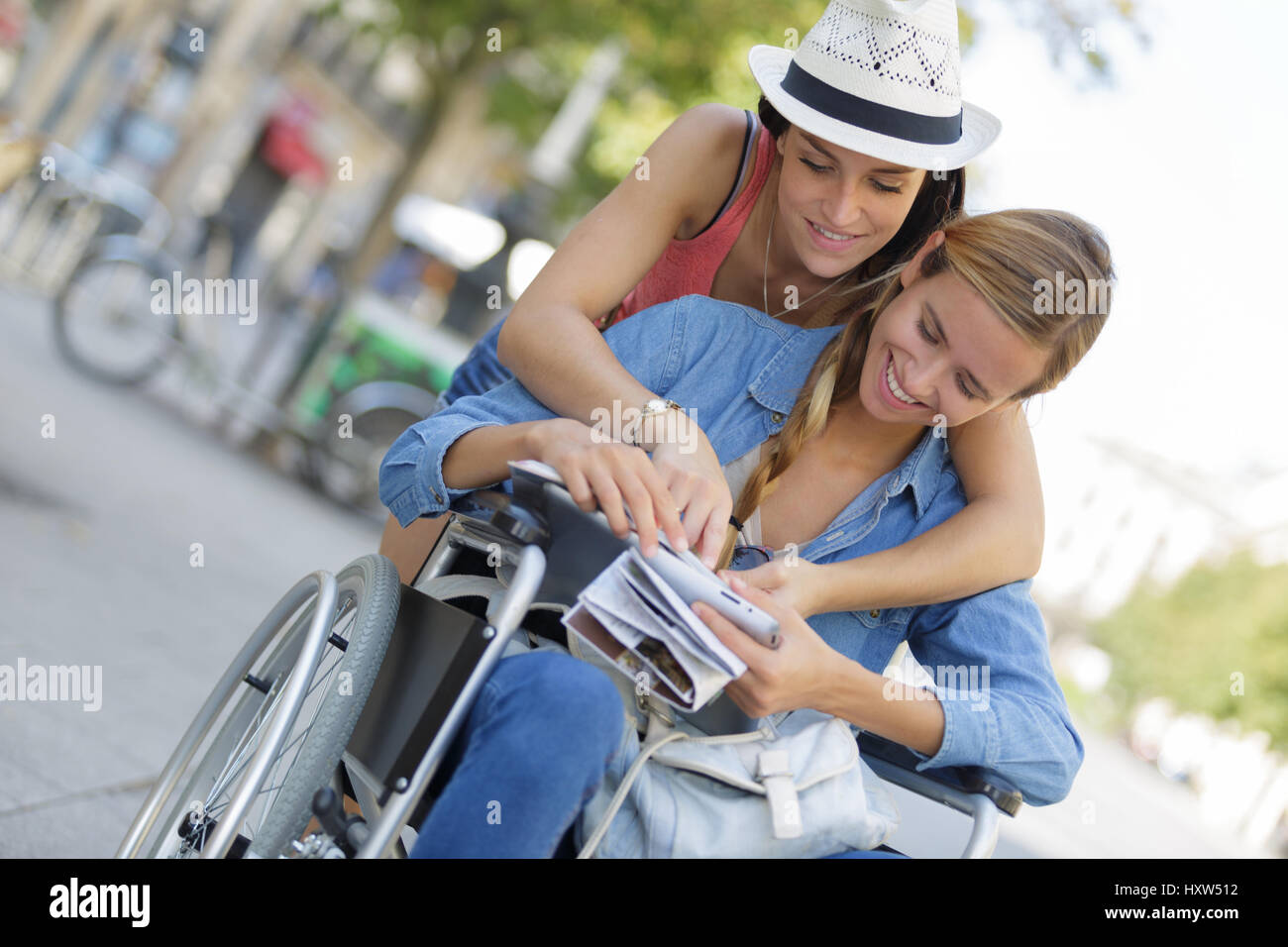 two friends visiting foreign city one sitting in wheelchair Stock Photo ...