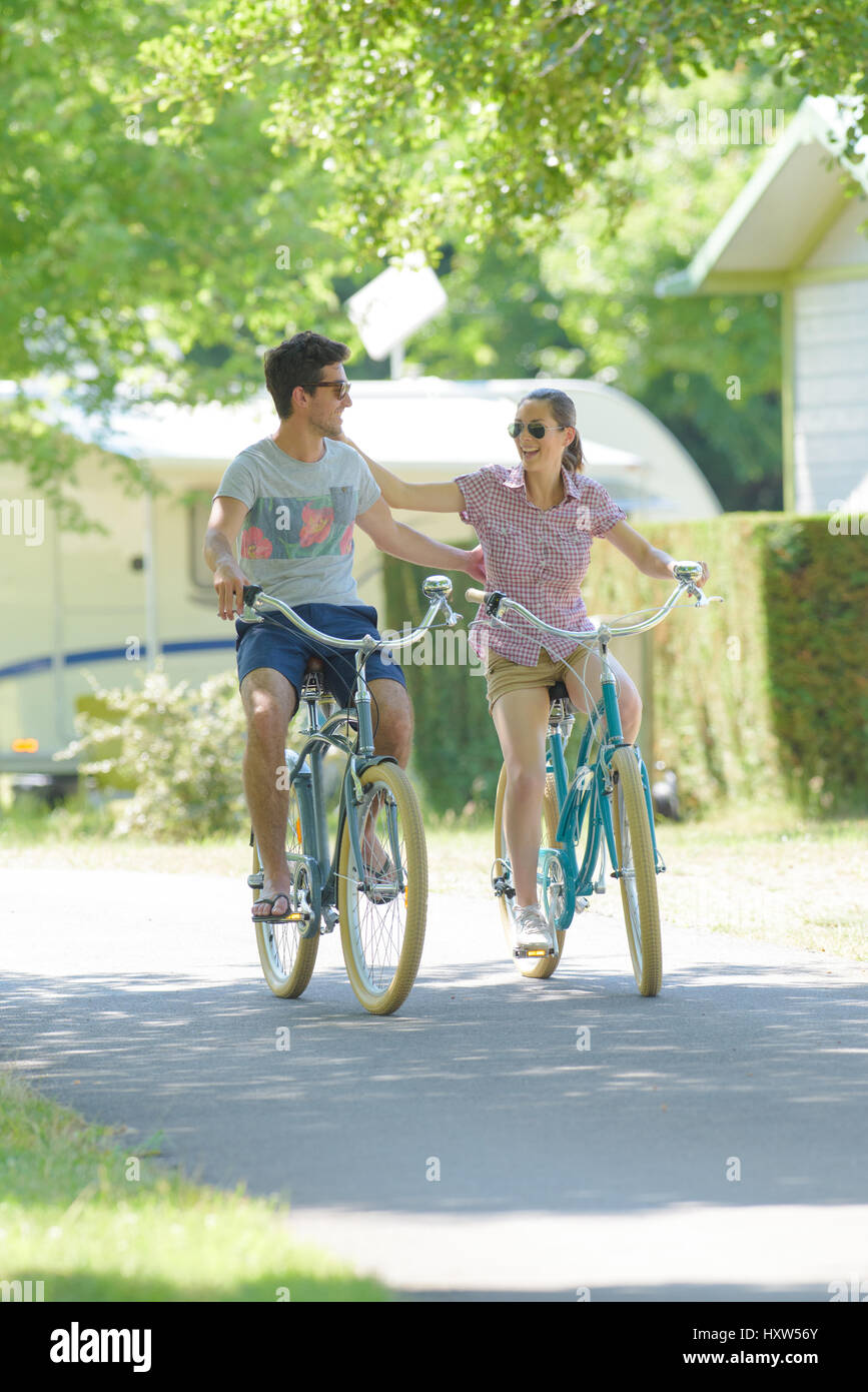 Couple cycling arms around each other Stock Photo - Alamy