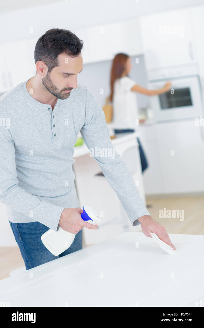 Man spraying kitchen table Stock Photo - Alamy