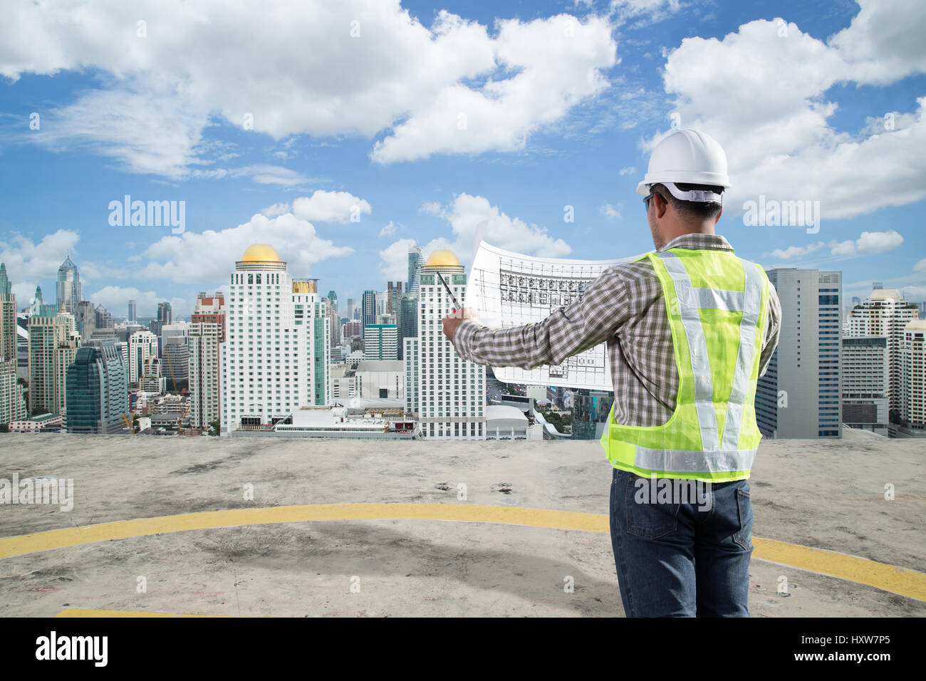 Construction engineer looking at blueprints for planning building ...