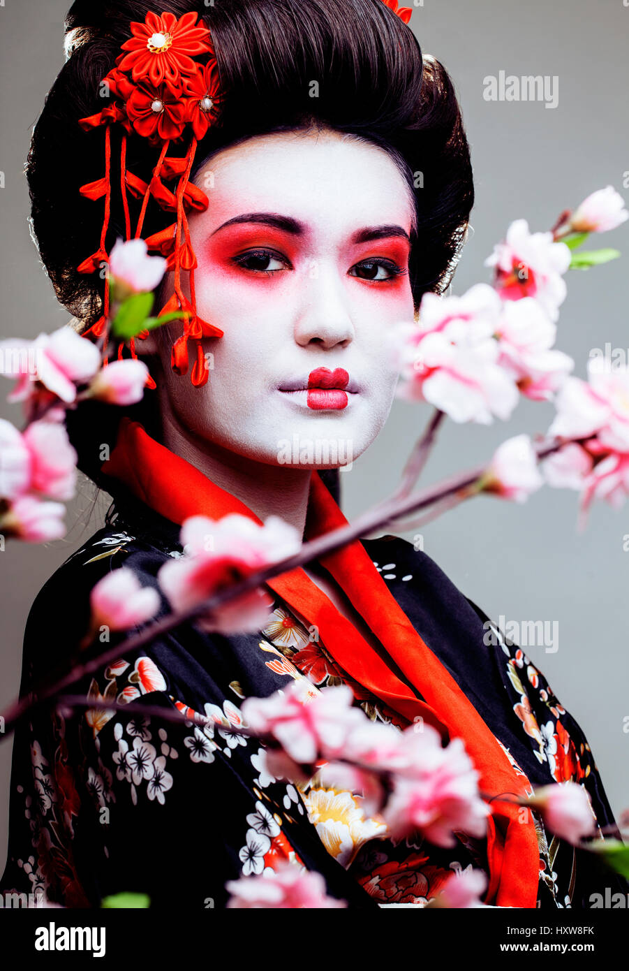 young pretty geisha in black kimono among sakura, asian ethno Stock ...