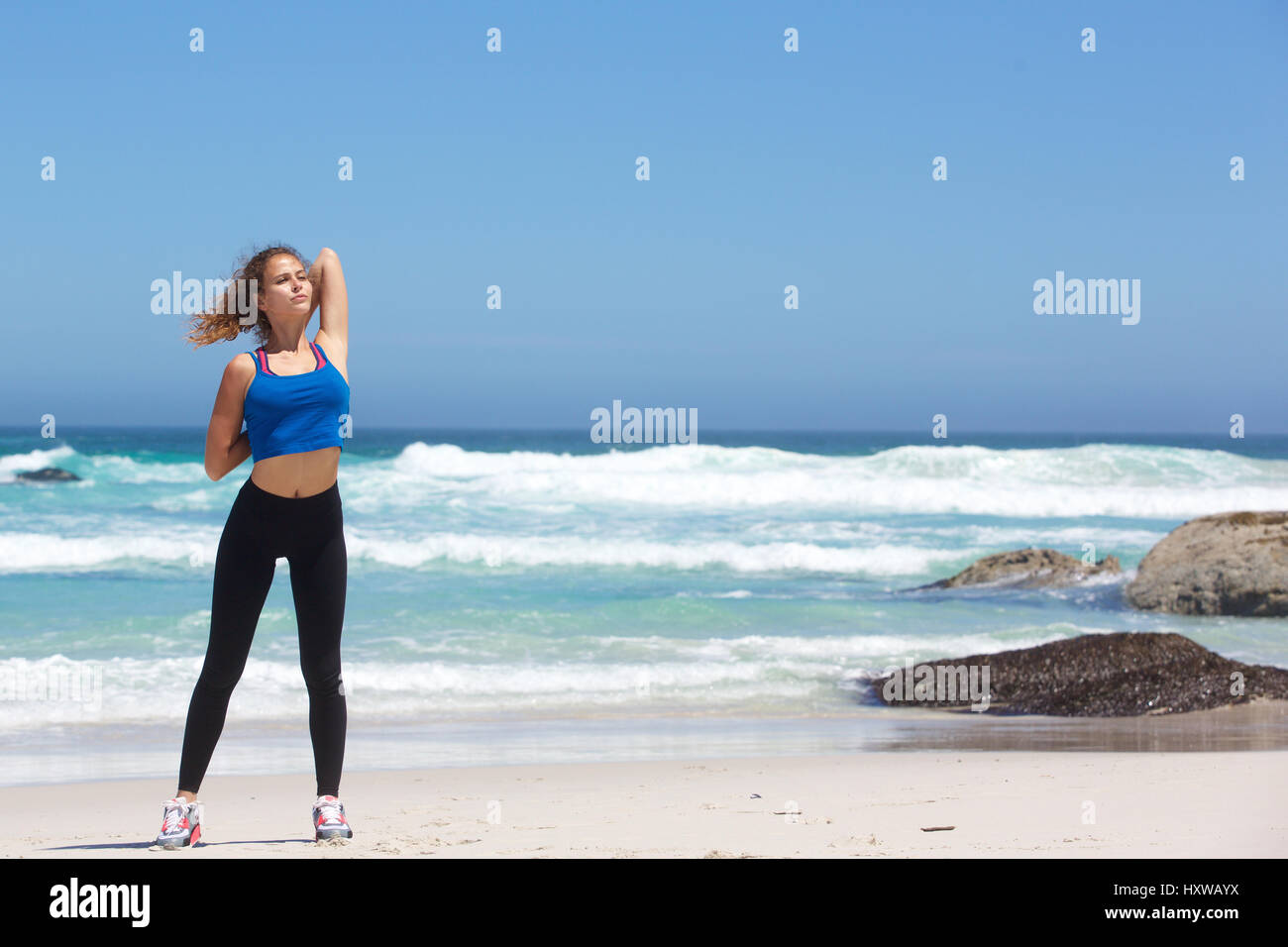 Full Body Portrait Of A Sporty Young Woman Stretching At The Beach