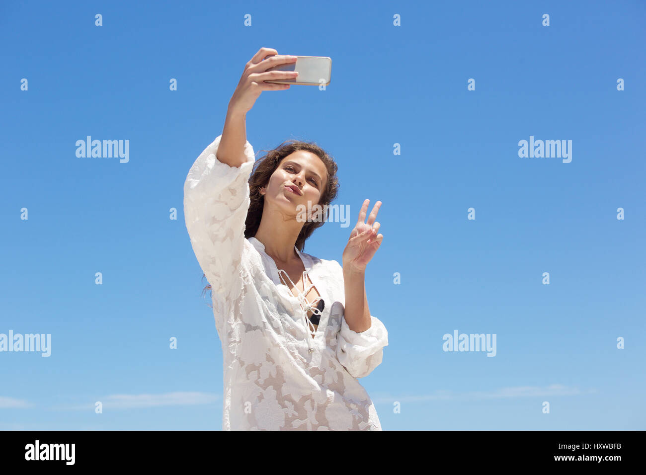Portrait of a young woman taking selfie with peace hand sign Stock ...