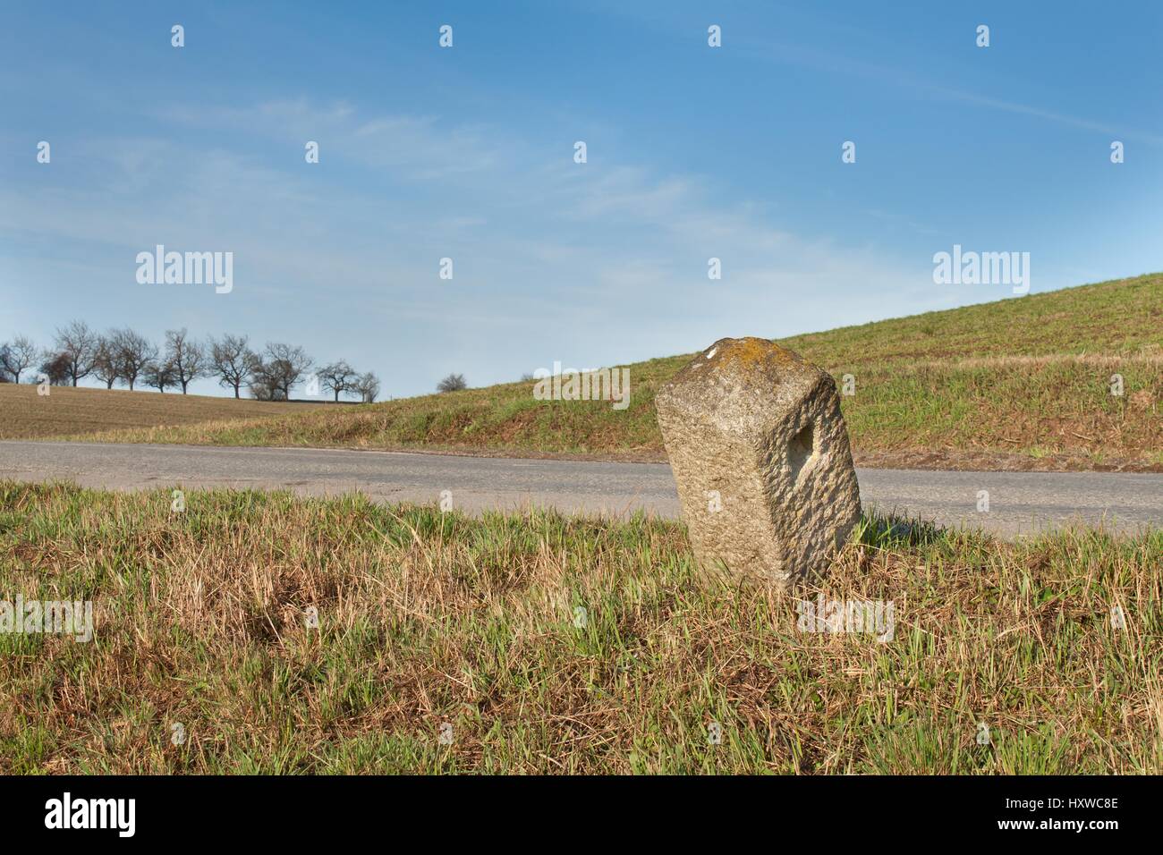 Old rural asphalt road in the Czech Republic. Granite road bollard ...