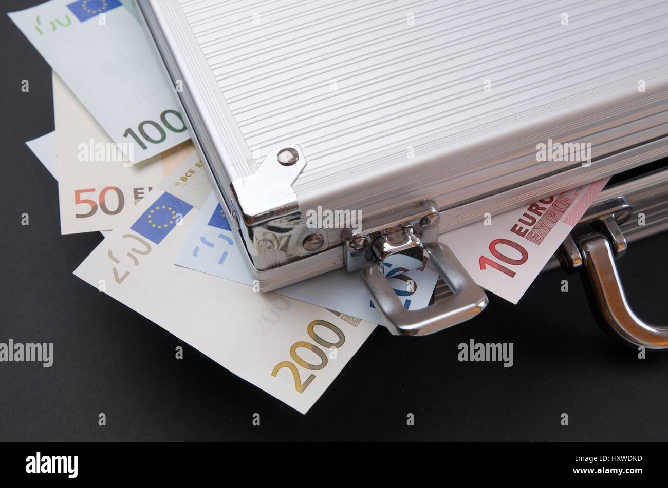 Euro banknotes protruding from a metal briefcase Stock Photo - Alamy
